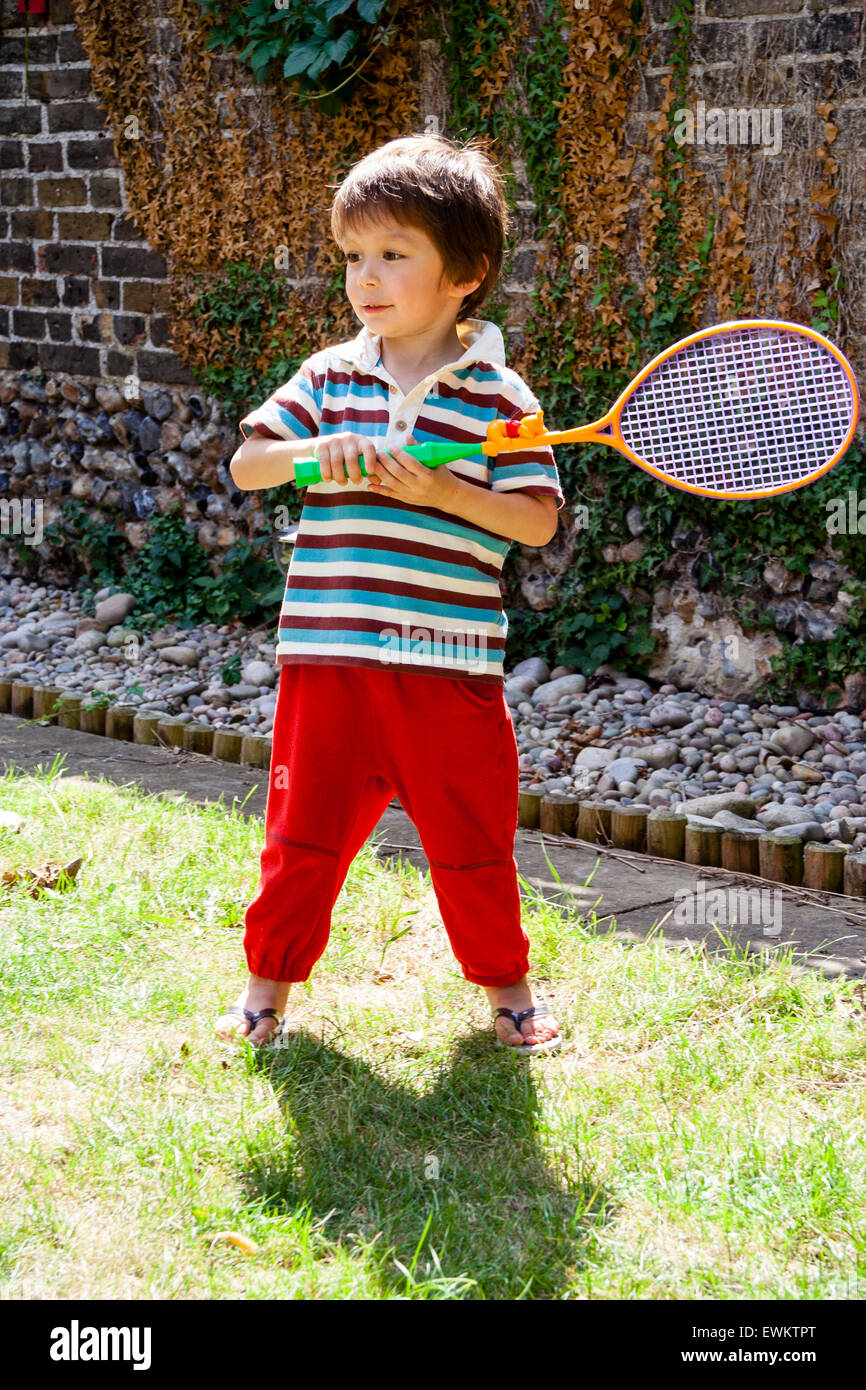 Caucasian child, boy, 4-5 year old, in garden, wearing t-shirt and ...