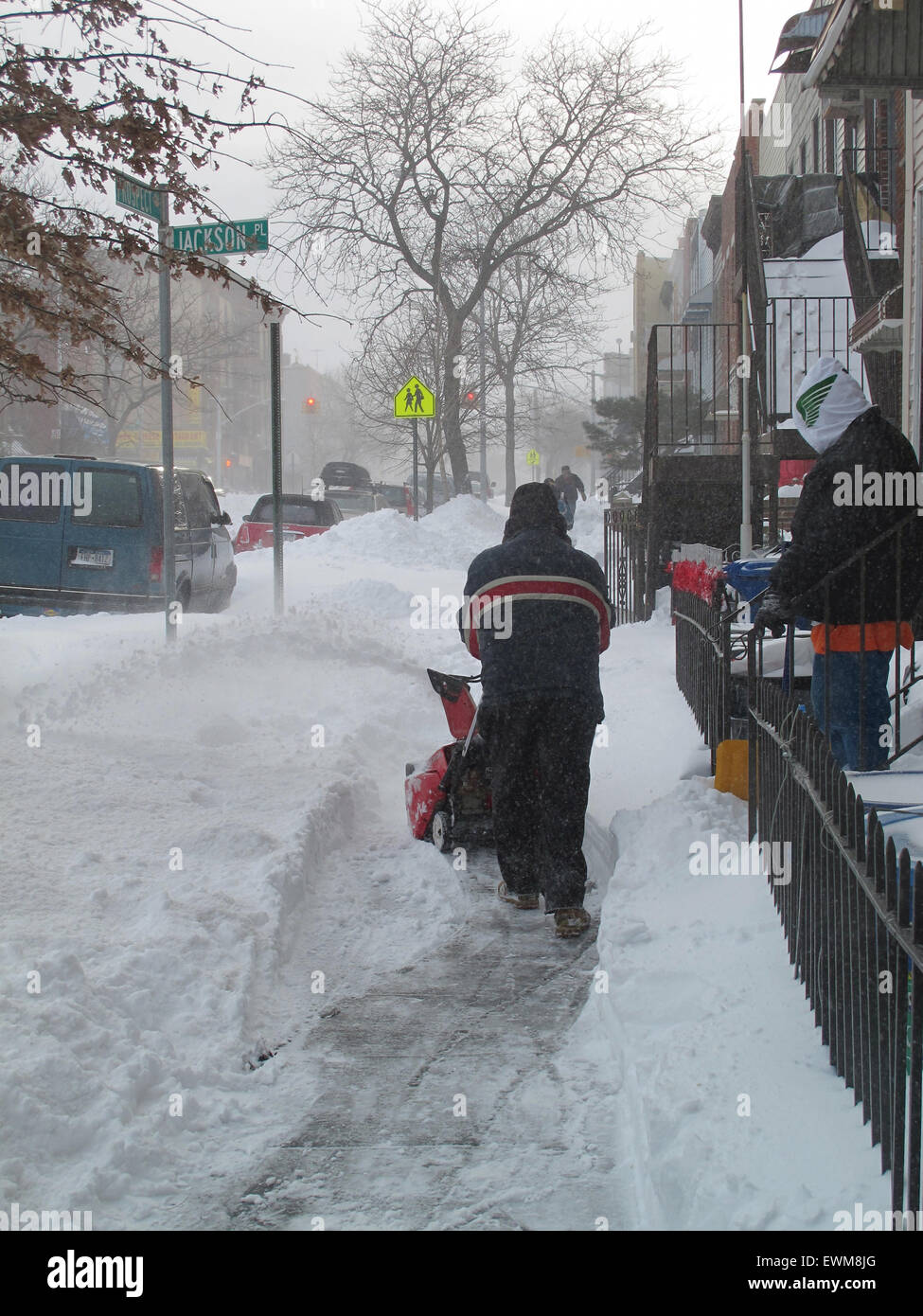 Man pushing snowblower on sidewalk in winter blizzard, Brooklyn, New ...