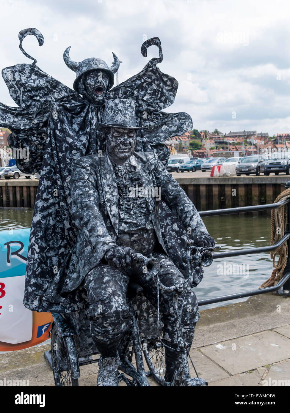 A man posing as a very elaborate living statue on a tricycle and with a ...
