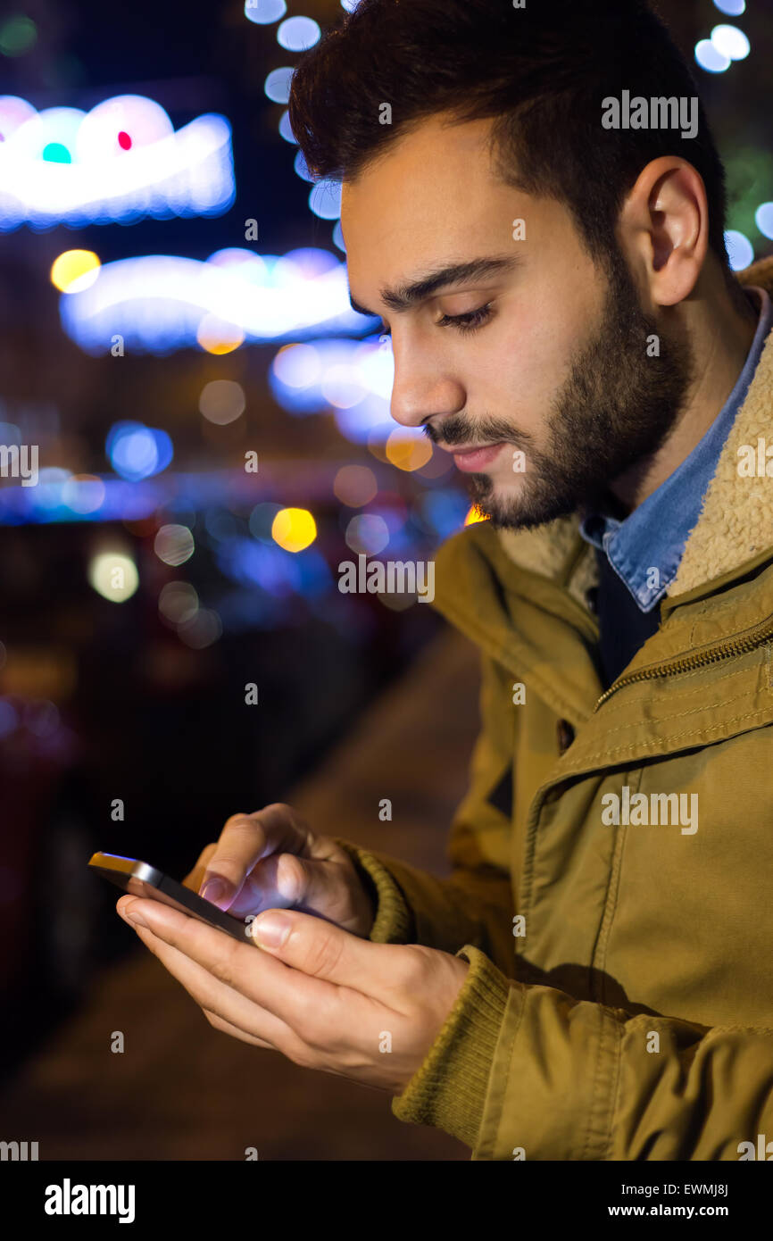 Outdoor portrait of young man using his mobile phone at night Stock ...