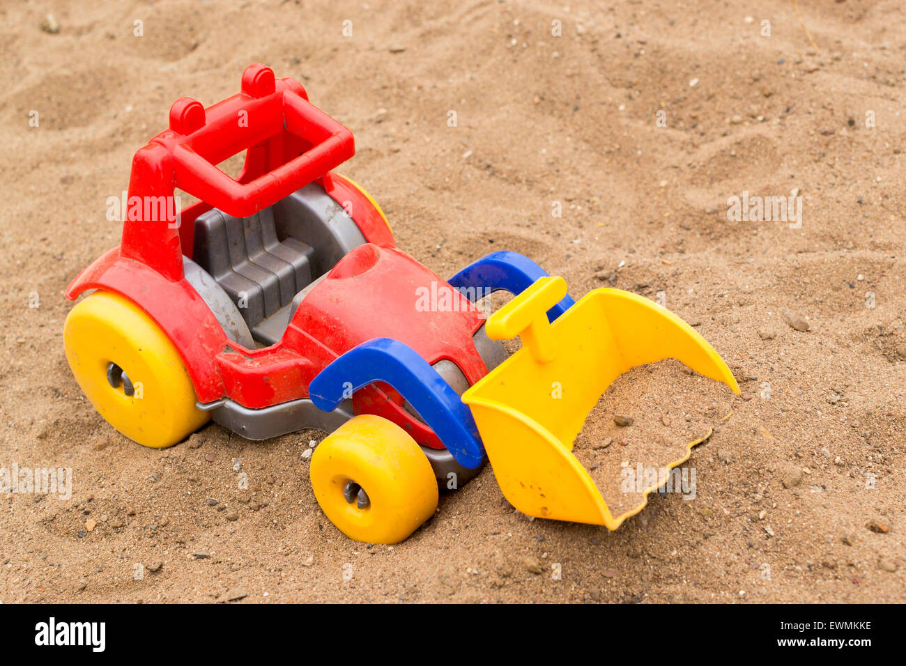 Child's toy digger in multicolored plastic in a sand pit Stock Photo ...