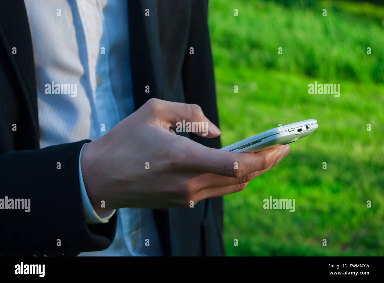 Young man wearing suit with smartphone Stock Photo - Alamy