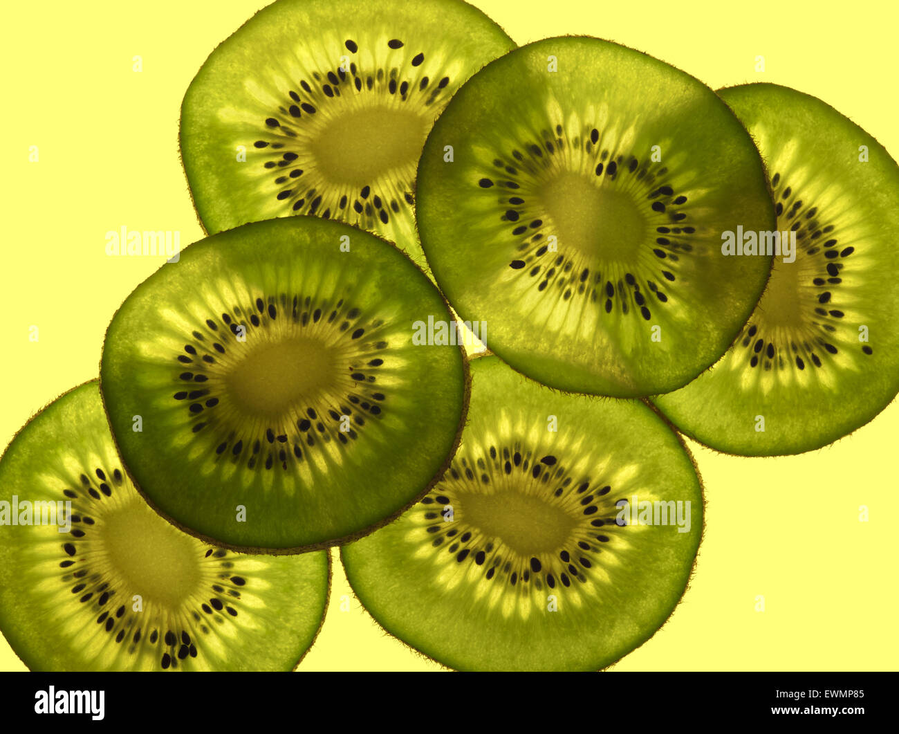 thin translucent kiwifruit slices in yellow back Stock Photo - Alamy