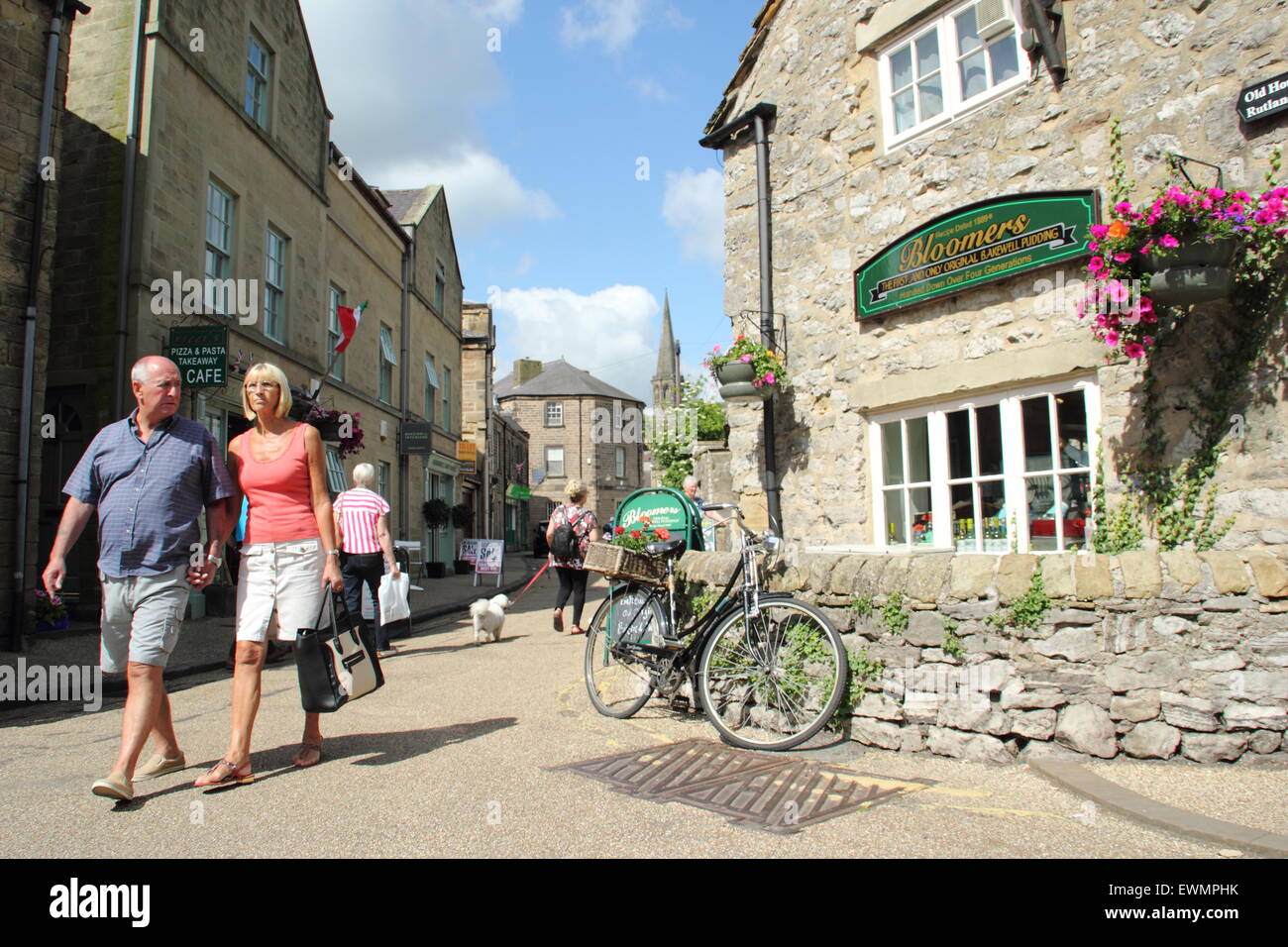 People walk through a pretty street in Bakewell, Peak District ...