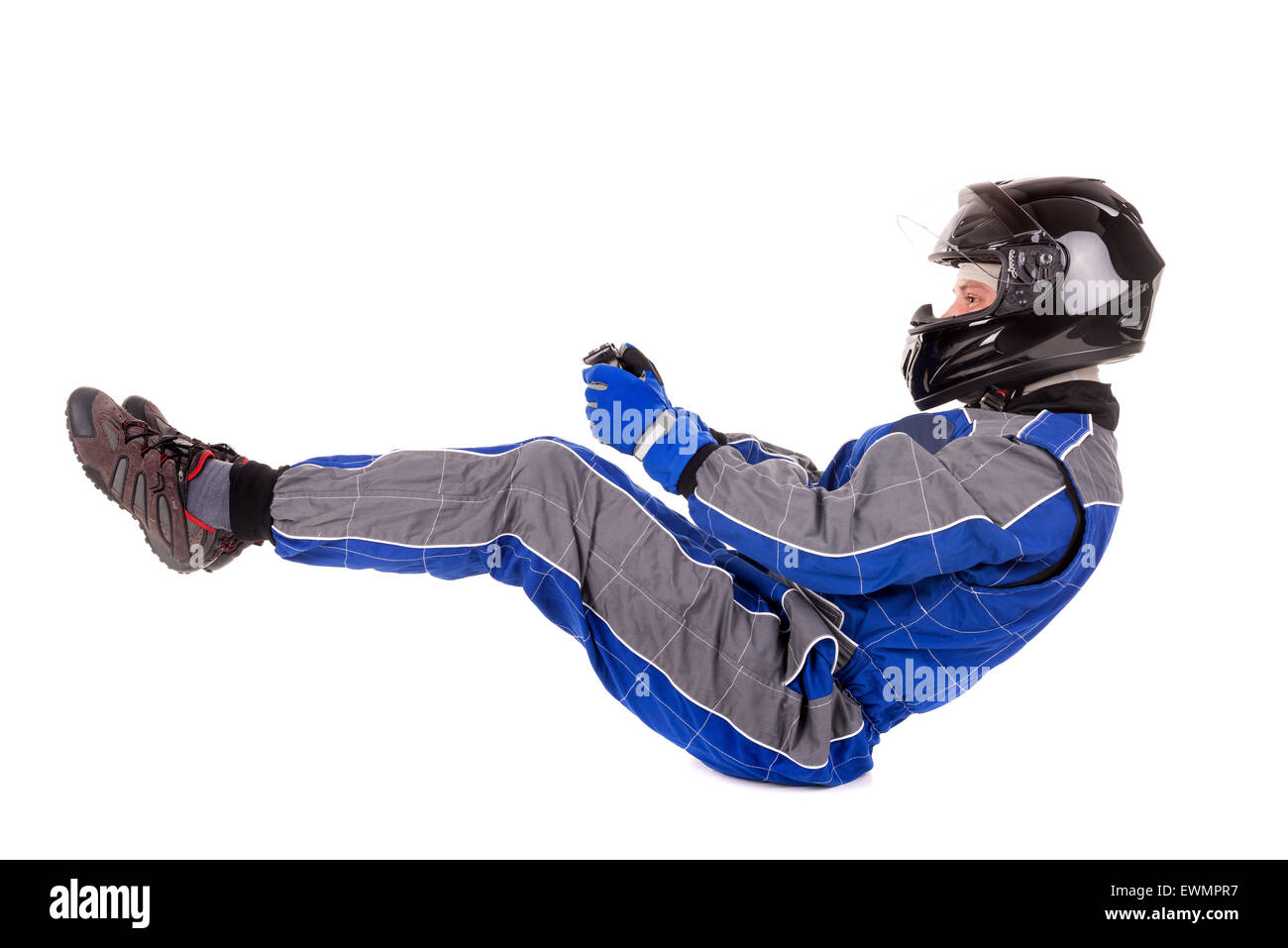 Racing driver posing in driving position in full gear isolated in white ...