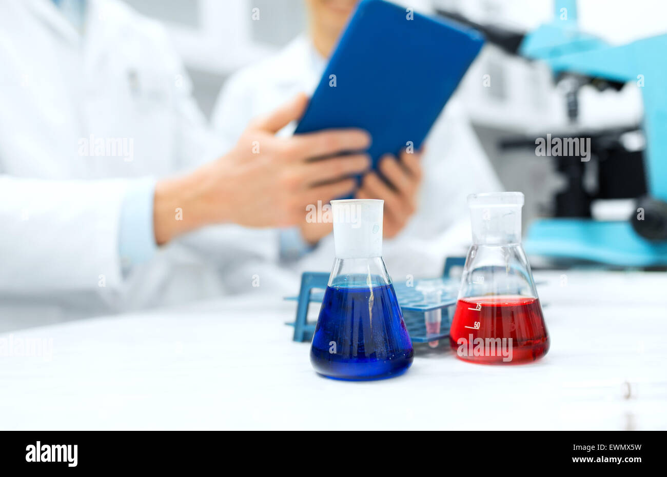 close up of scientists with flasks and tablet pc Stock Photo - Alamy