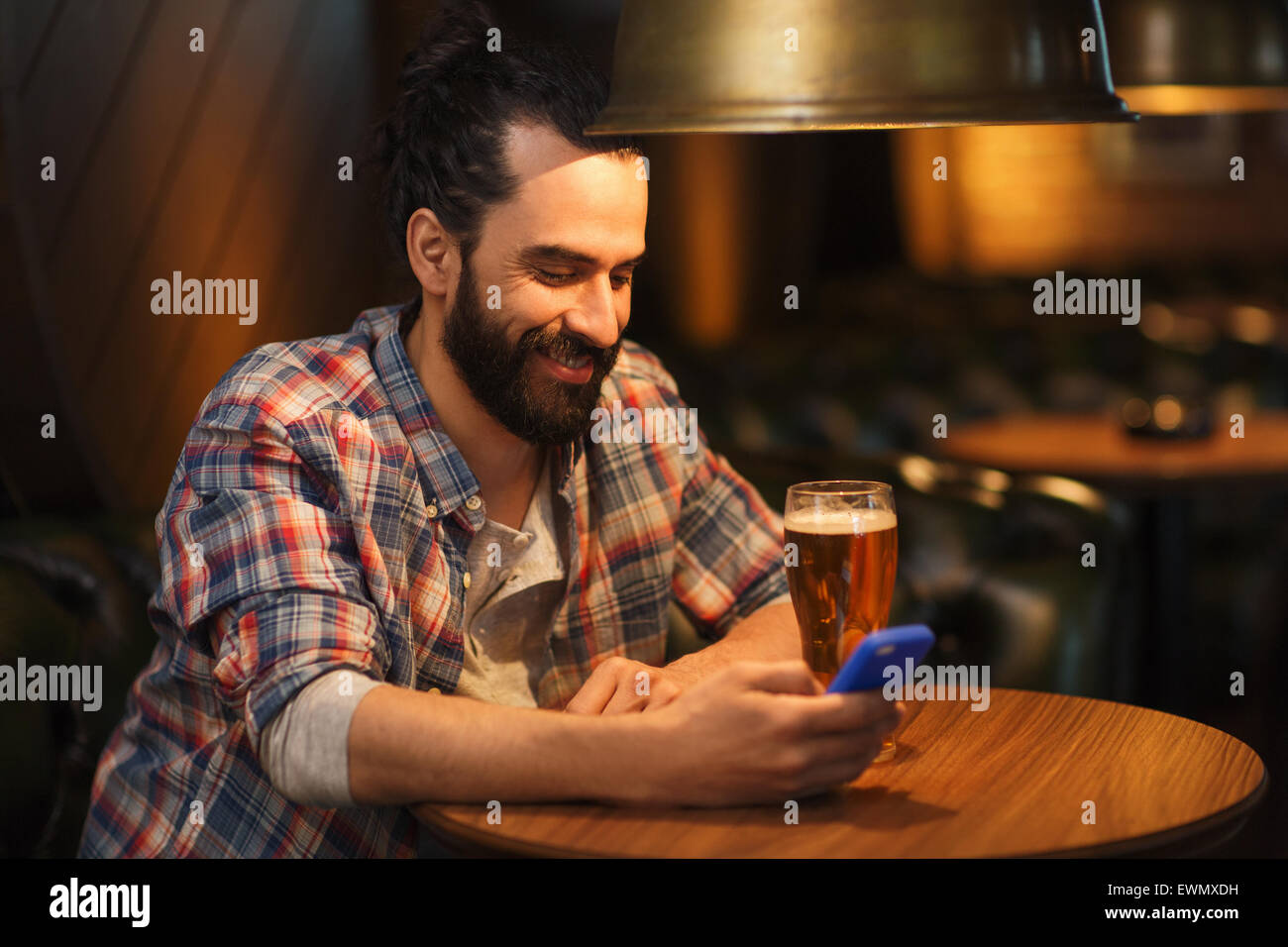man with smartphone and beer texting at bar Stock Photo - Alamy