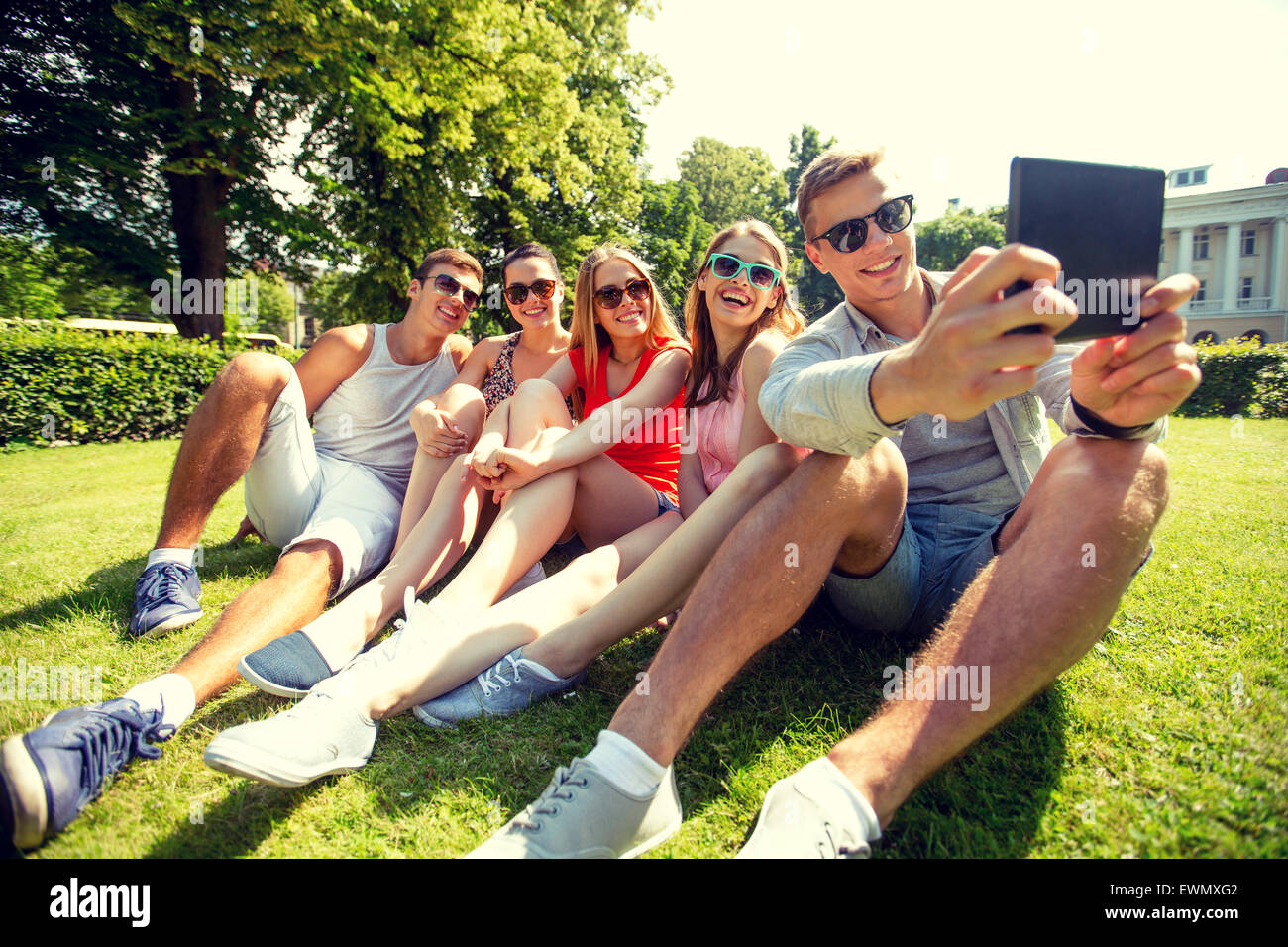 smiling friends with tablet pc computer in park Stock Photo - Alamy