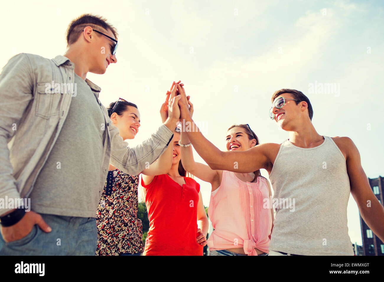 group of smiling friends making high five outdoors Stock Photo - Alamy