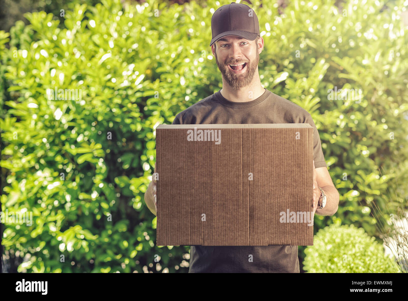 Cute bearded guy in a peaked cap with a happy exuberant grin making a ...