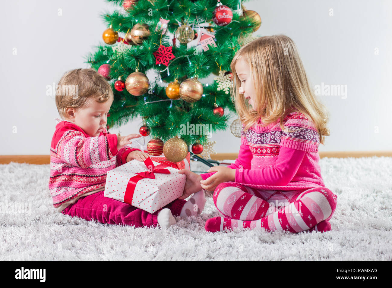 Happy children open Christmas presents on the floor and tree with New ...