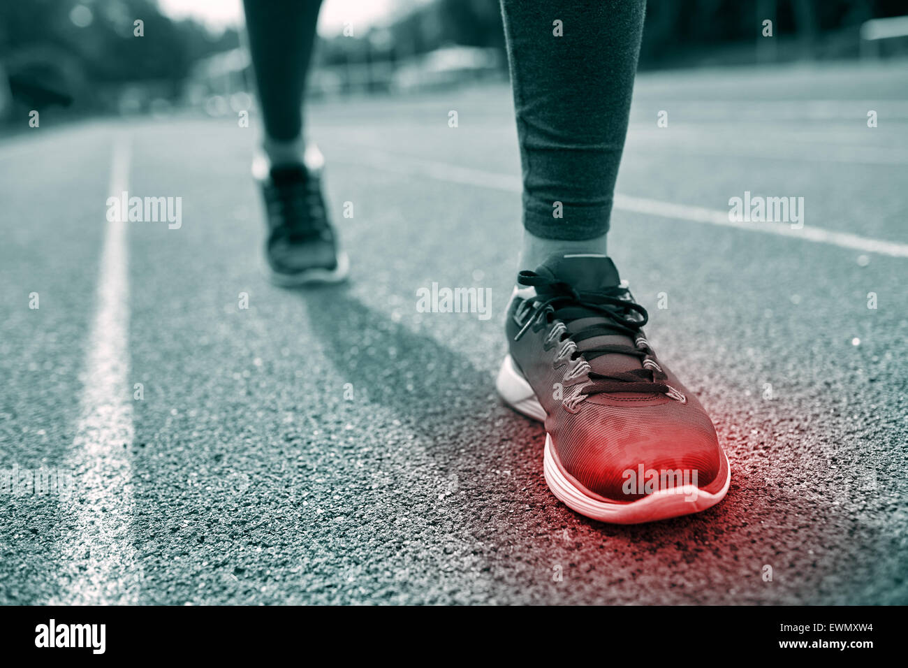 close up of feet with red spot running on track Stock Photo - Alamy