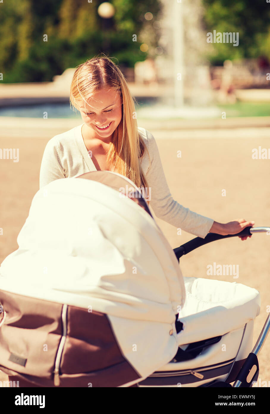 happy mother with stroller in park Stock Photo - Alamy