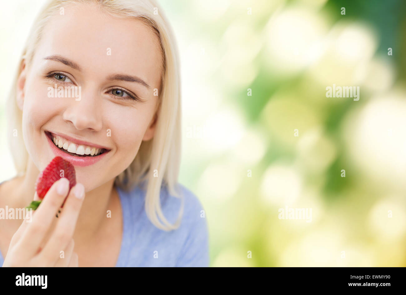 happy woman eating strawberry at home Stock Photo - Alamy