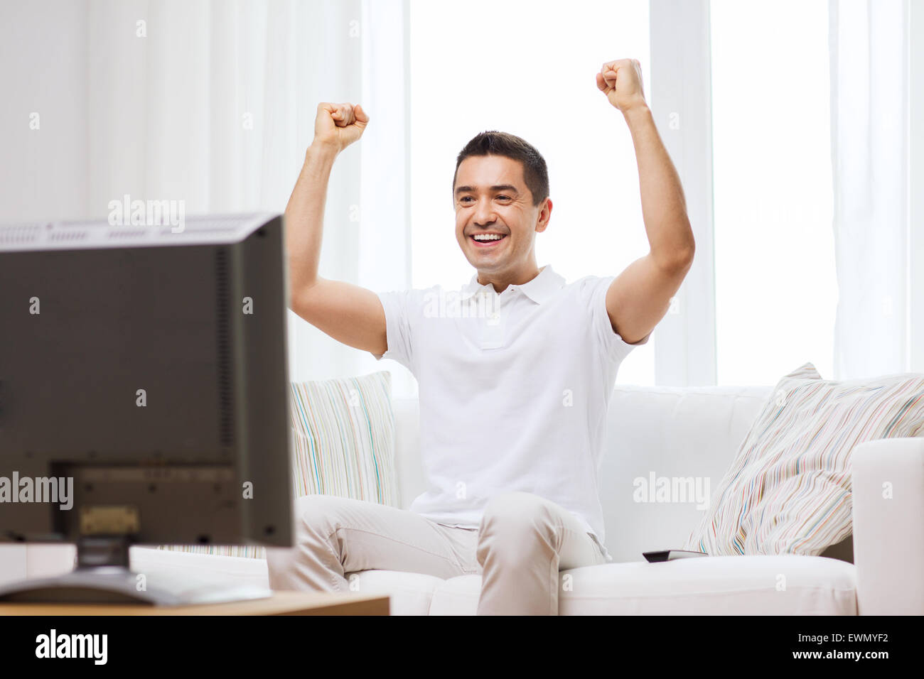 smiling man watching sports at home Stock Photo - Alamy