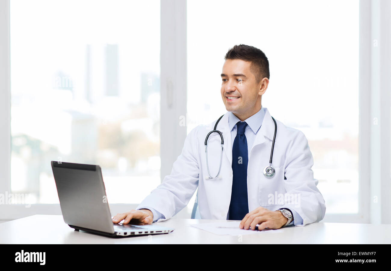 smiling male doctor with laptop in medical office Stock Photo - Alamy