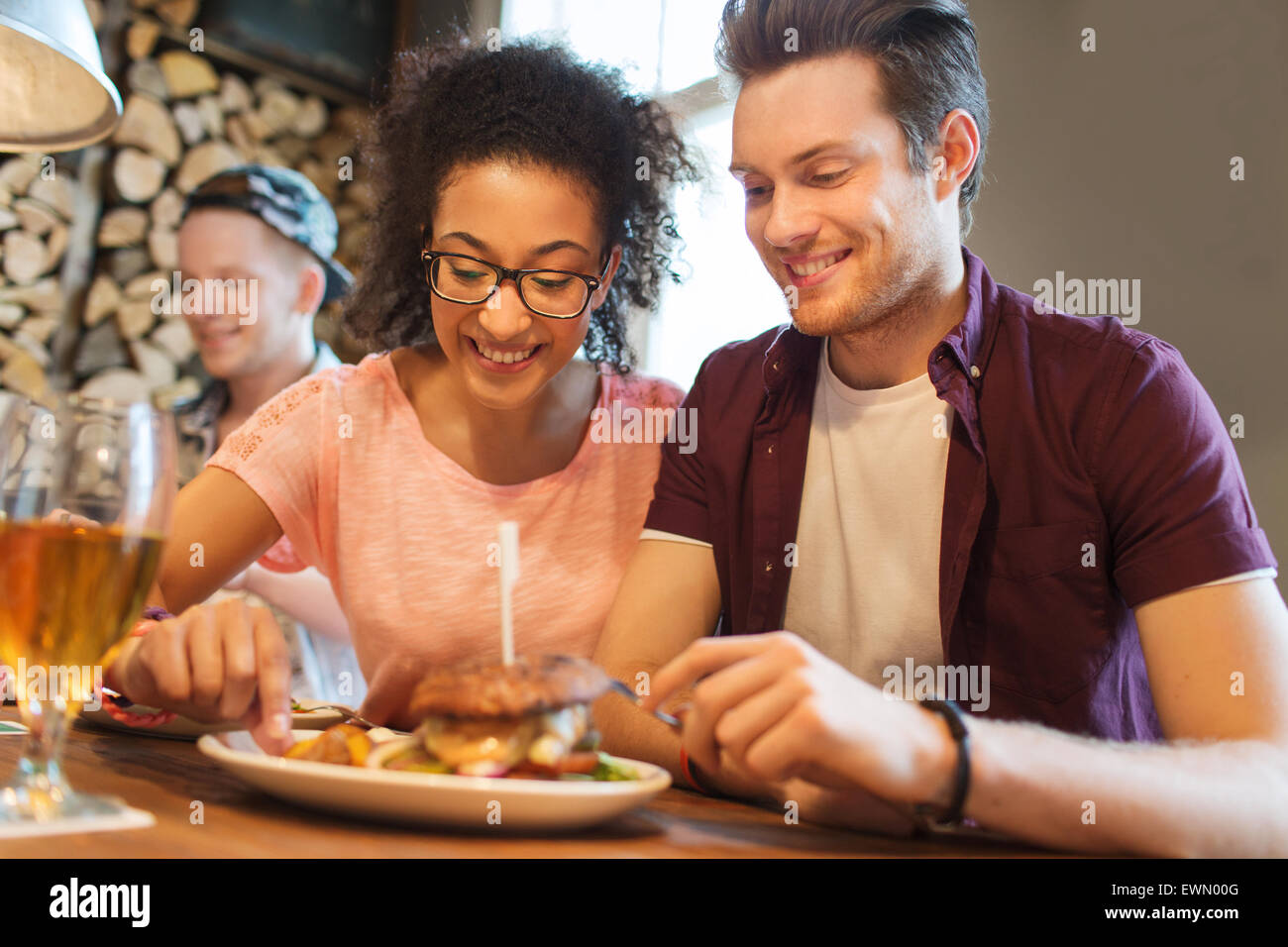 happy friends eating and drinking at bar or pub Stock Photo - Alamy