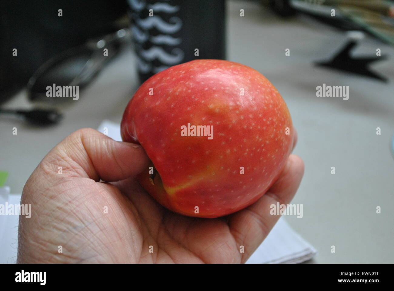 male hand holding a red apple Stock Photo - Alamy