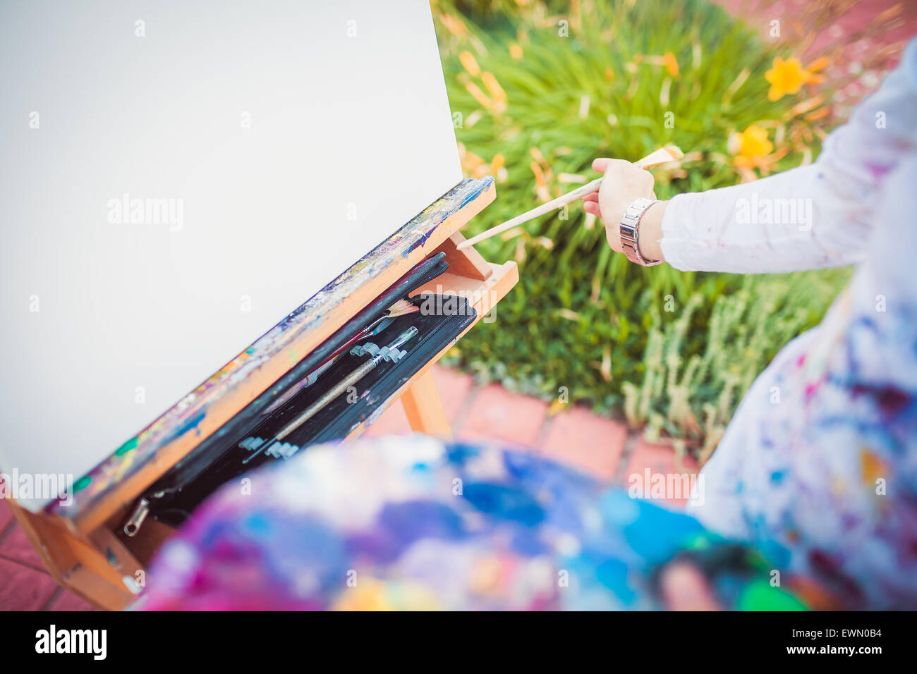 Hand with paintbrush and easel Stock Photo - Alamy