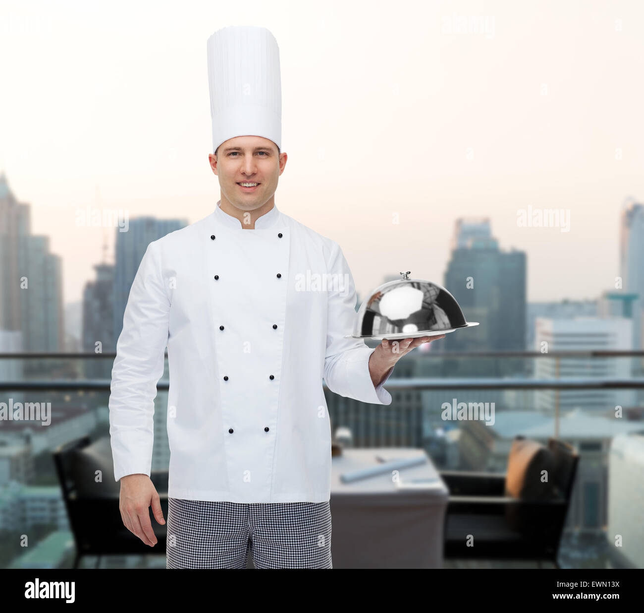 happy male chef cook holding cloche Stock Photo - Alamy