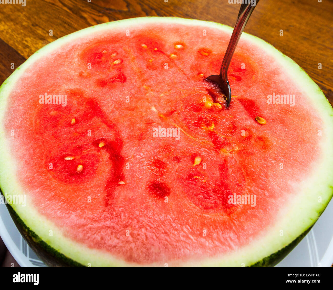 A seedless watermelon slice with a spoon in it Stock Photo - Alamy