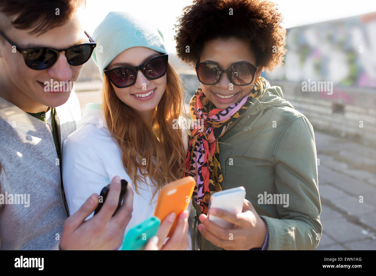smiling friends with smartphones Stock Photo - Alamy