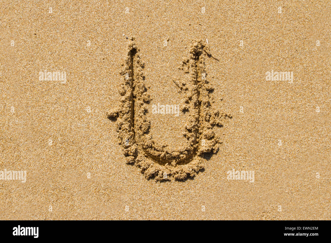 Letter U of the alphabet written on sand with upper case Stock Photo ...