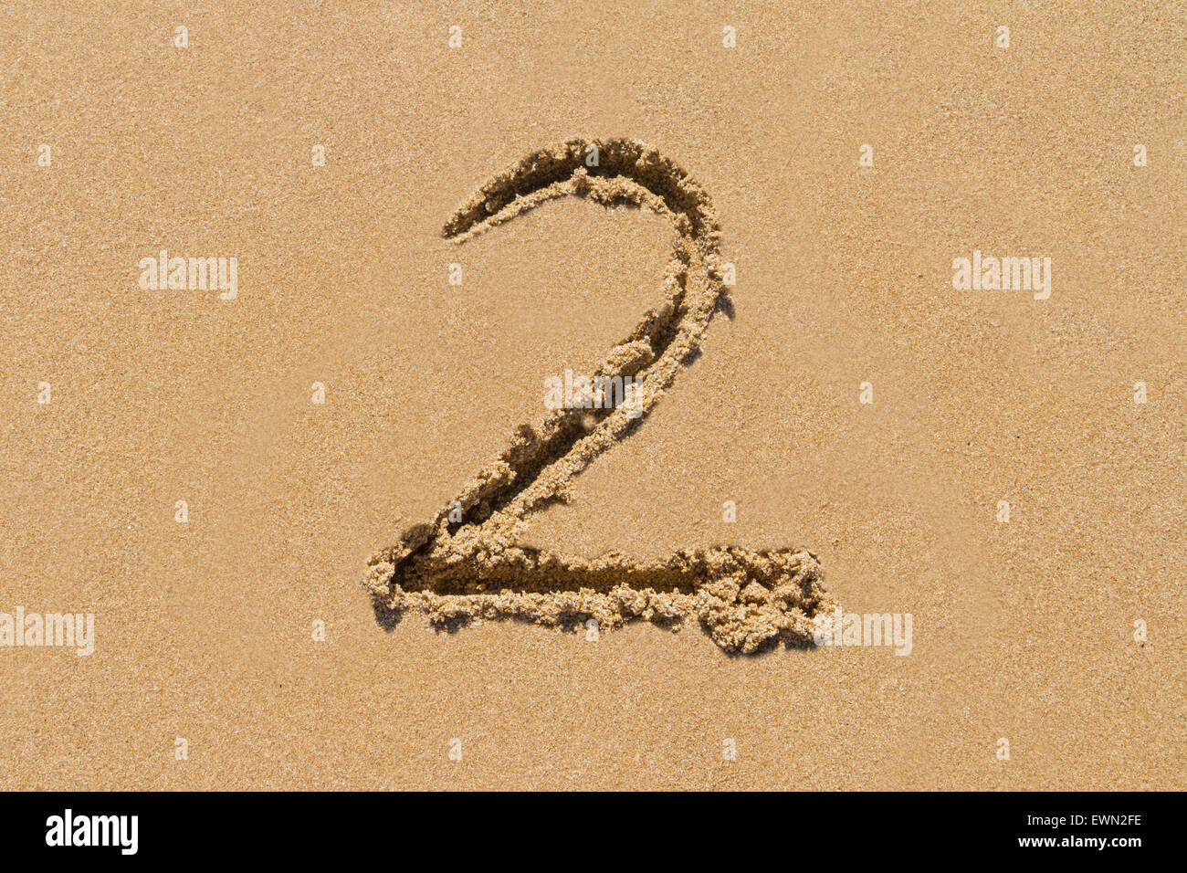 The number 2 drawn on sand at the beach, holiday concept background ...