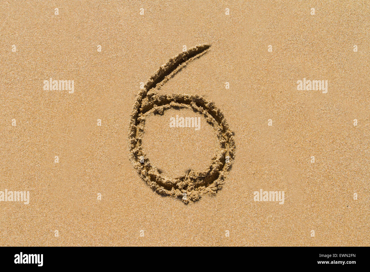 The number 6 drawn on sand at the beach, holiday concept background ...