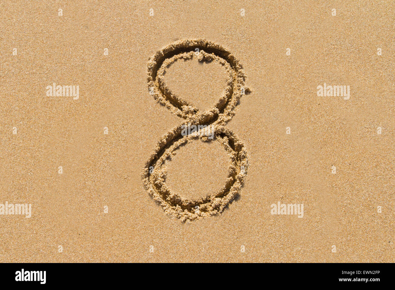 The number 8 drawn on sand at the beach, holiday concept background ...