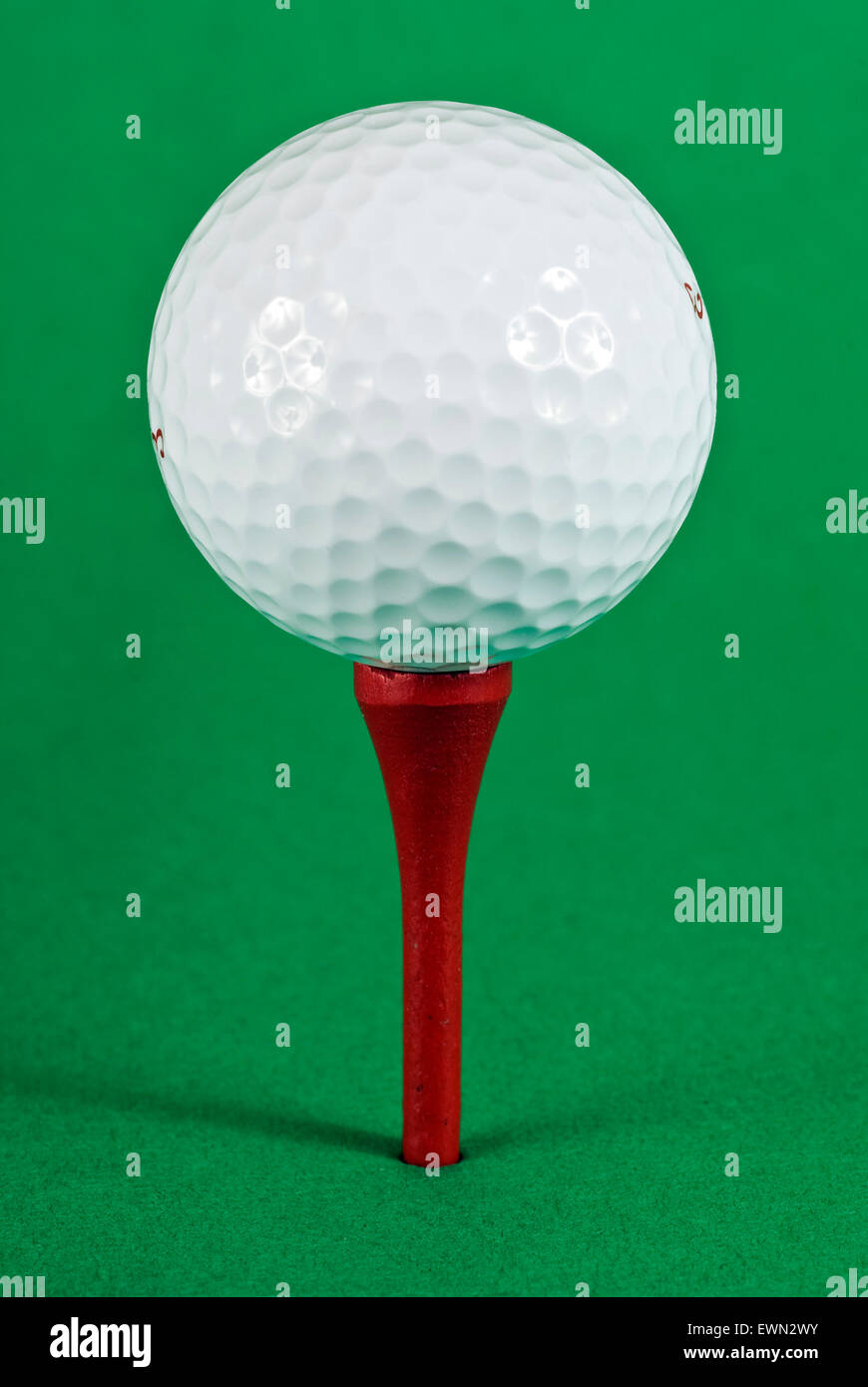 Golf ball on red tee shot in studio with green background Stock Photo ...