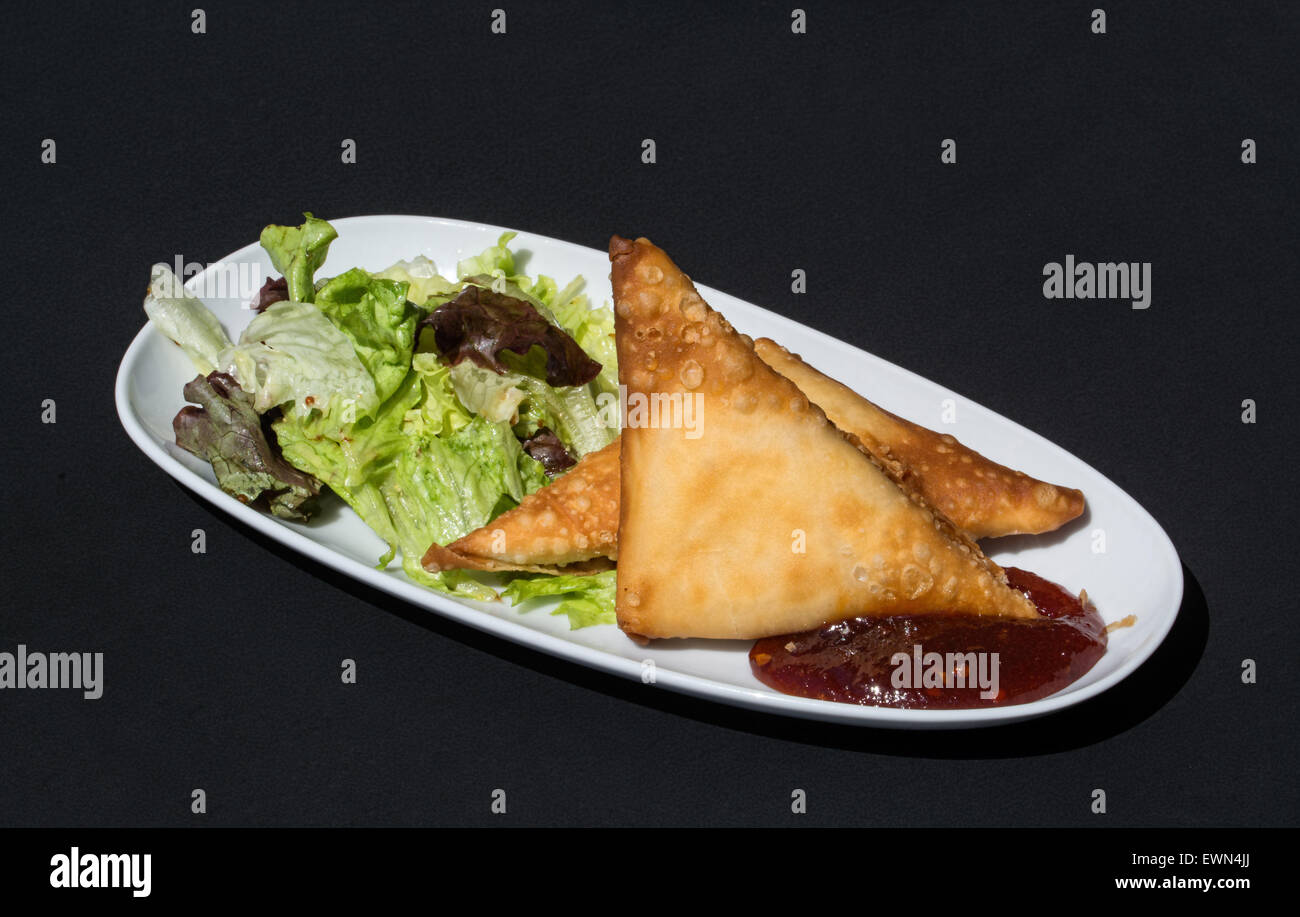 Two samosas in black background Stock Photo - Alamy