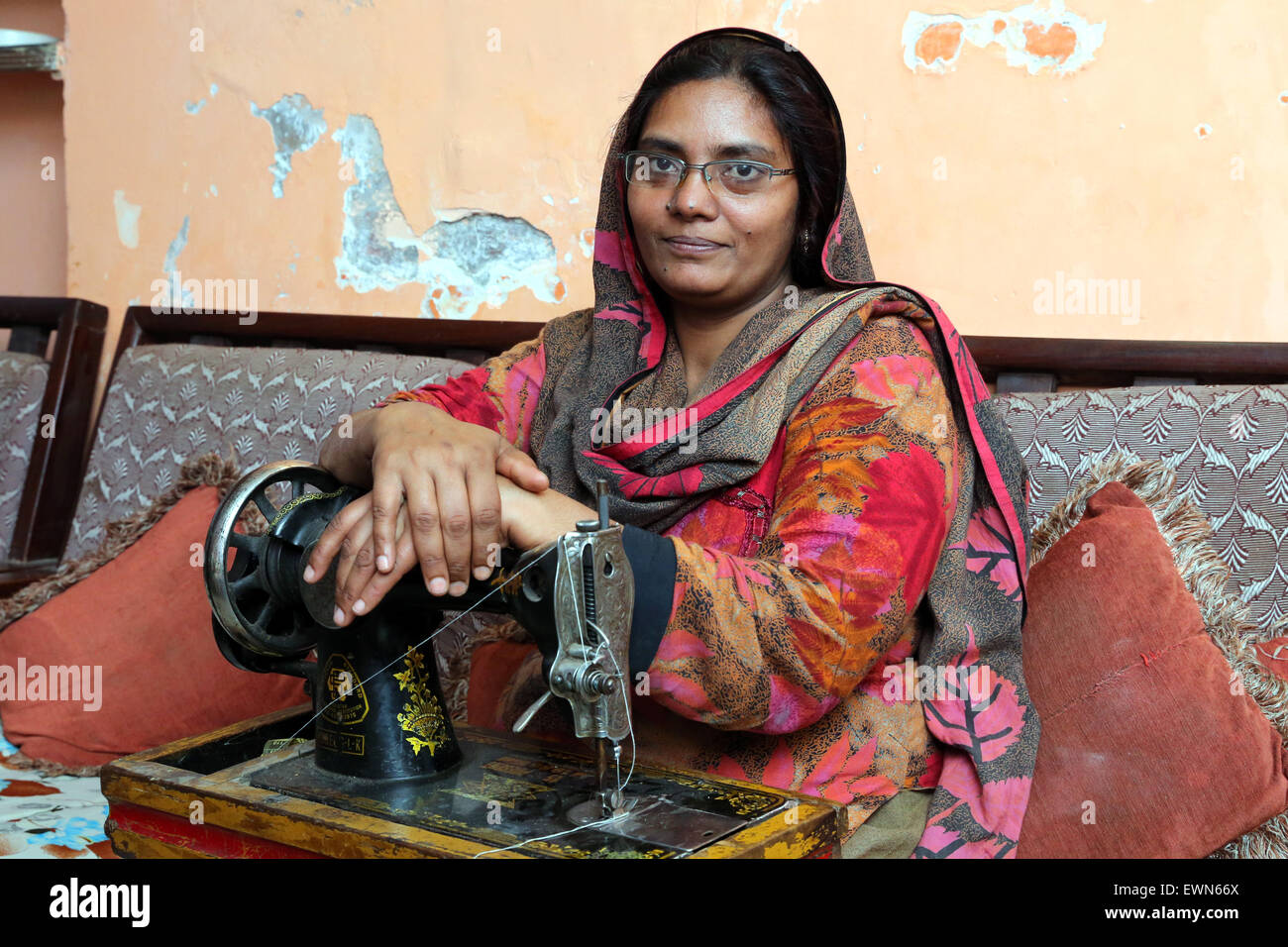 Portrait of a pakistani woman (age 39) sitting at home behind her ...