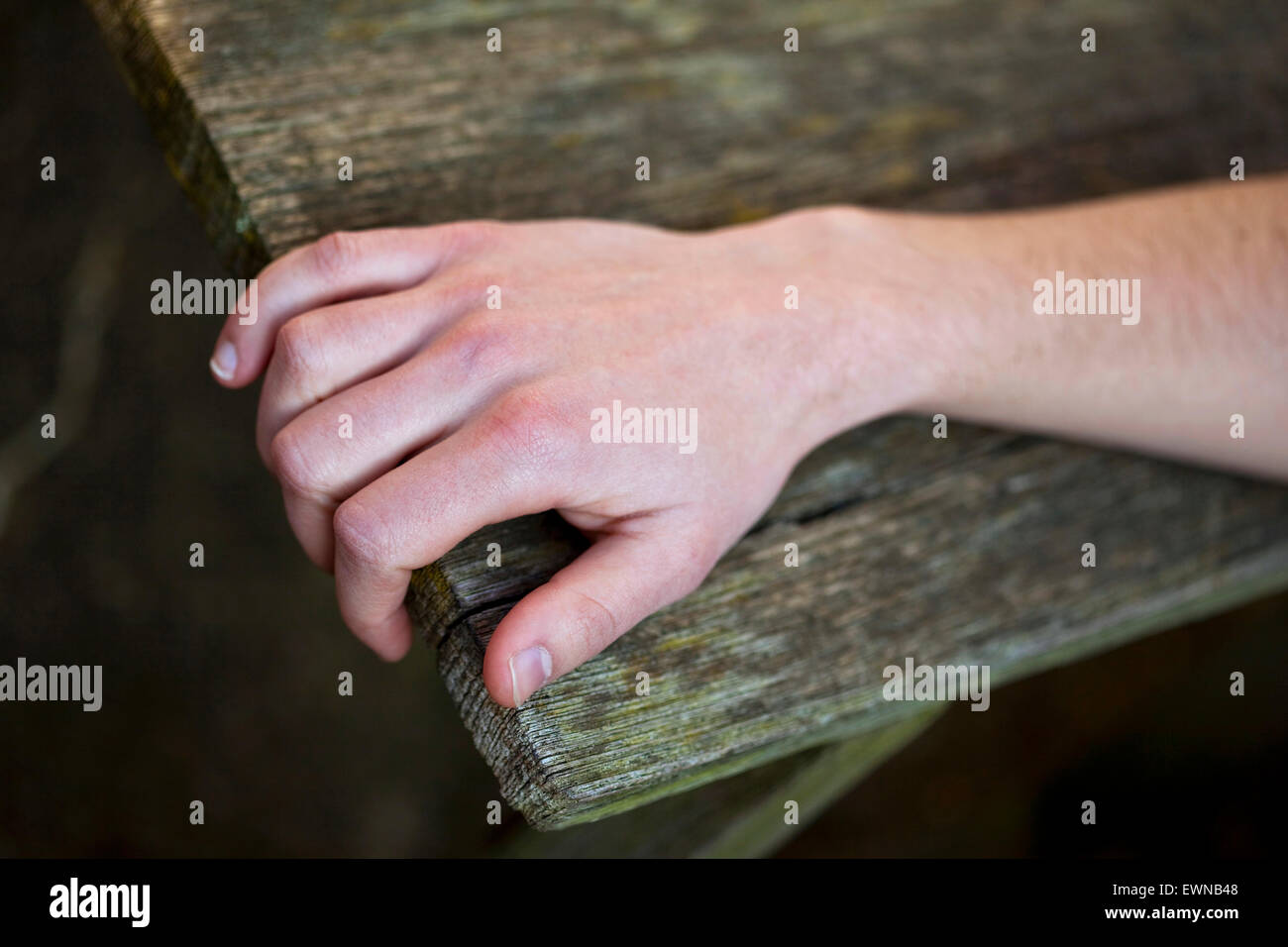 Human hand on the edge of a wooden table Stock Photo - Alamy