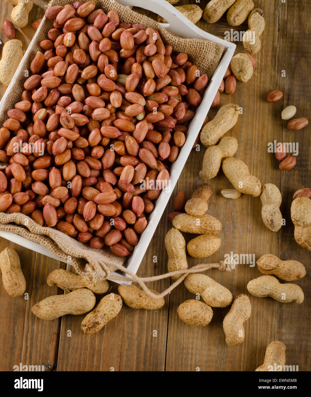 Peanuts in white box on wooden table. Top view Stock Photo - Alamy