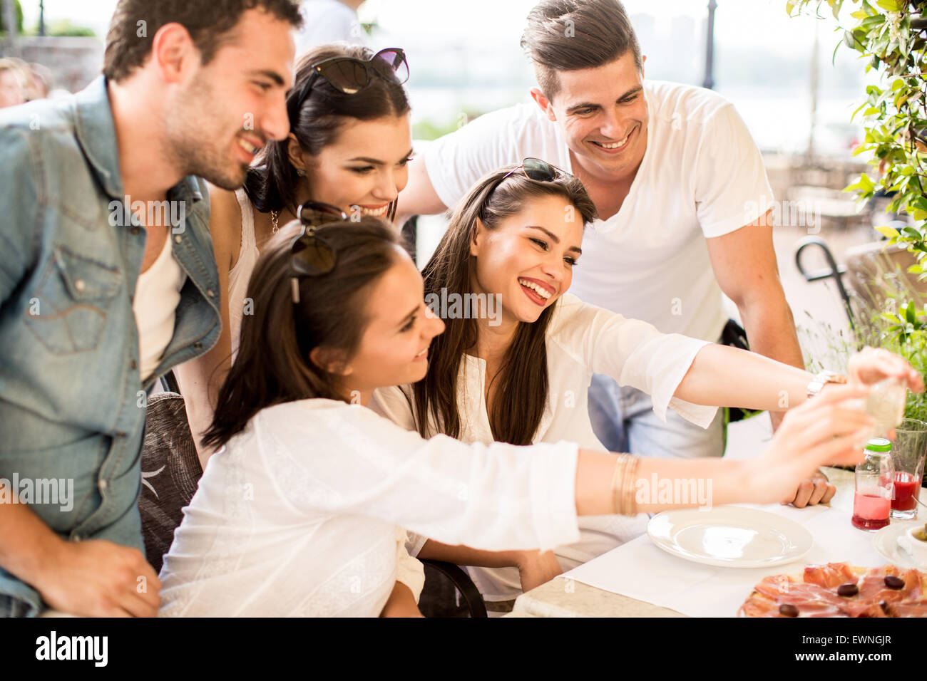 Young people taking photo by the table Stock Photo - Alamy