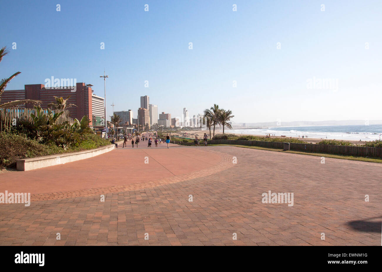 Many unknown early morning visitors walk along beach front promenade in ...