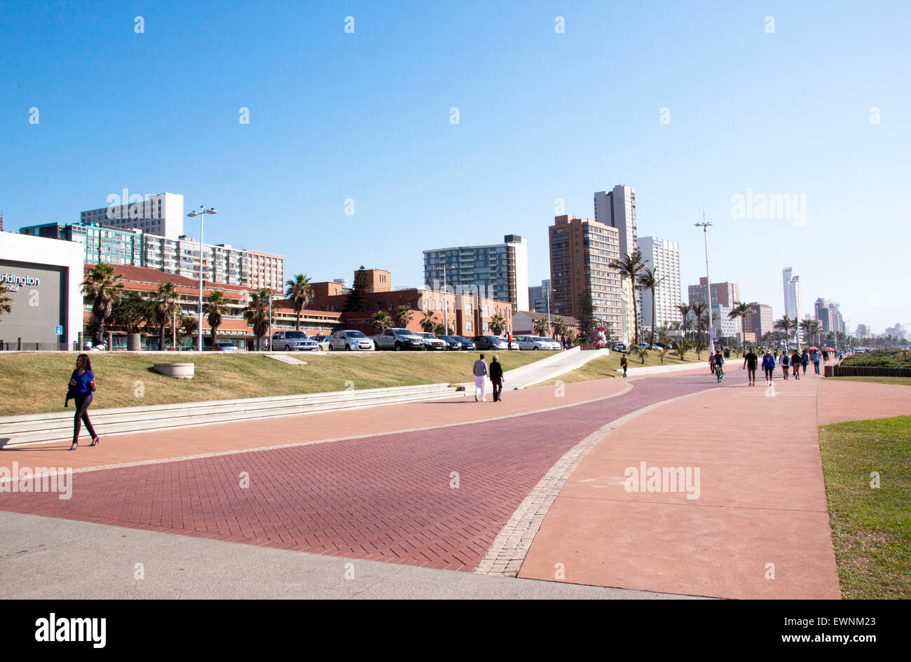 Many unknown people on early morning walk along beach front promenade ...