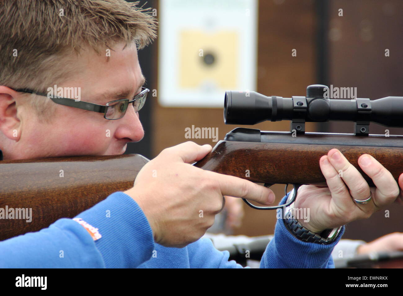 A man takes aim at a target practice stall at an English country fair ...