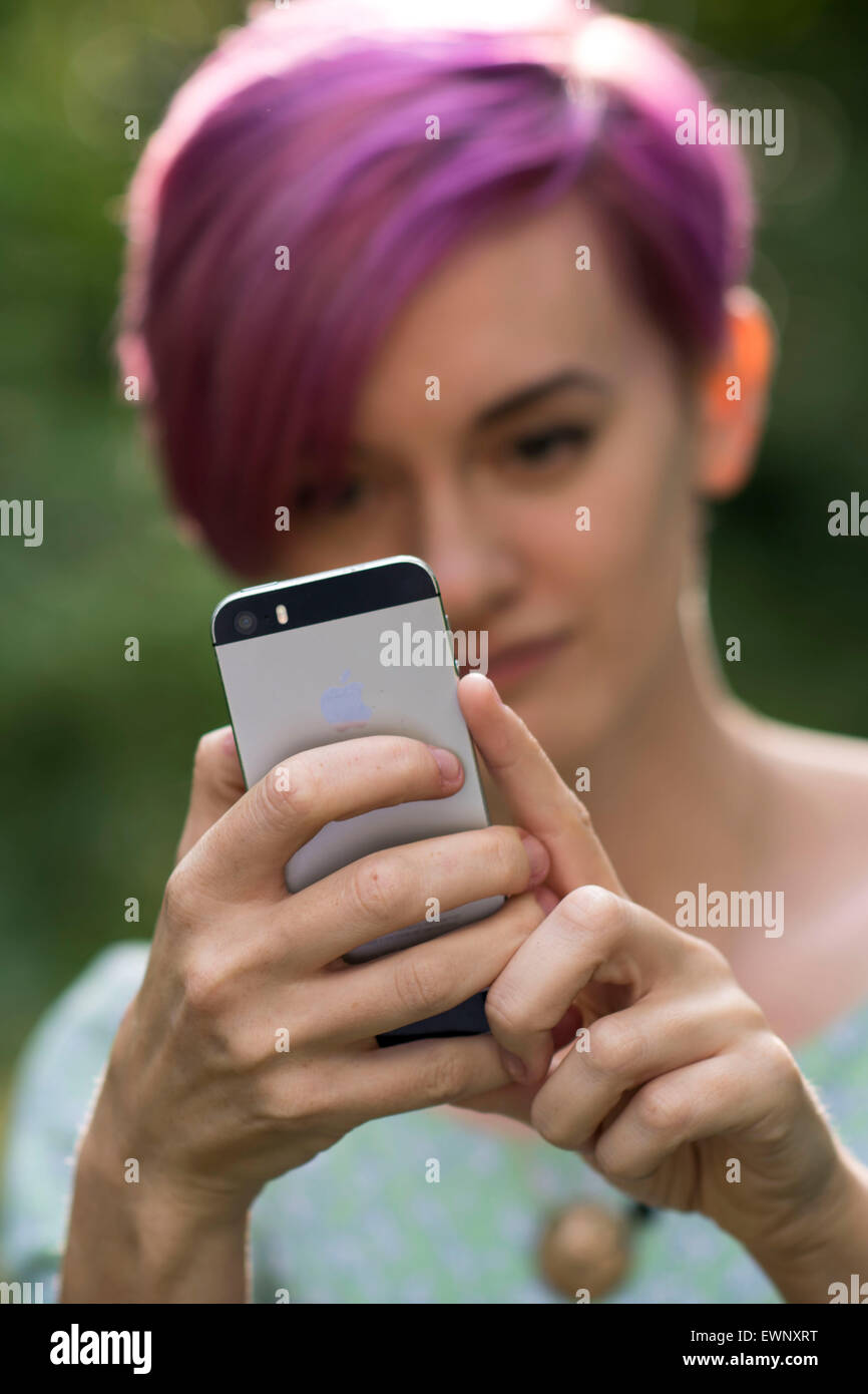 A girl using an Apple iPhone to take a picture Stock Photo - Alamy