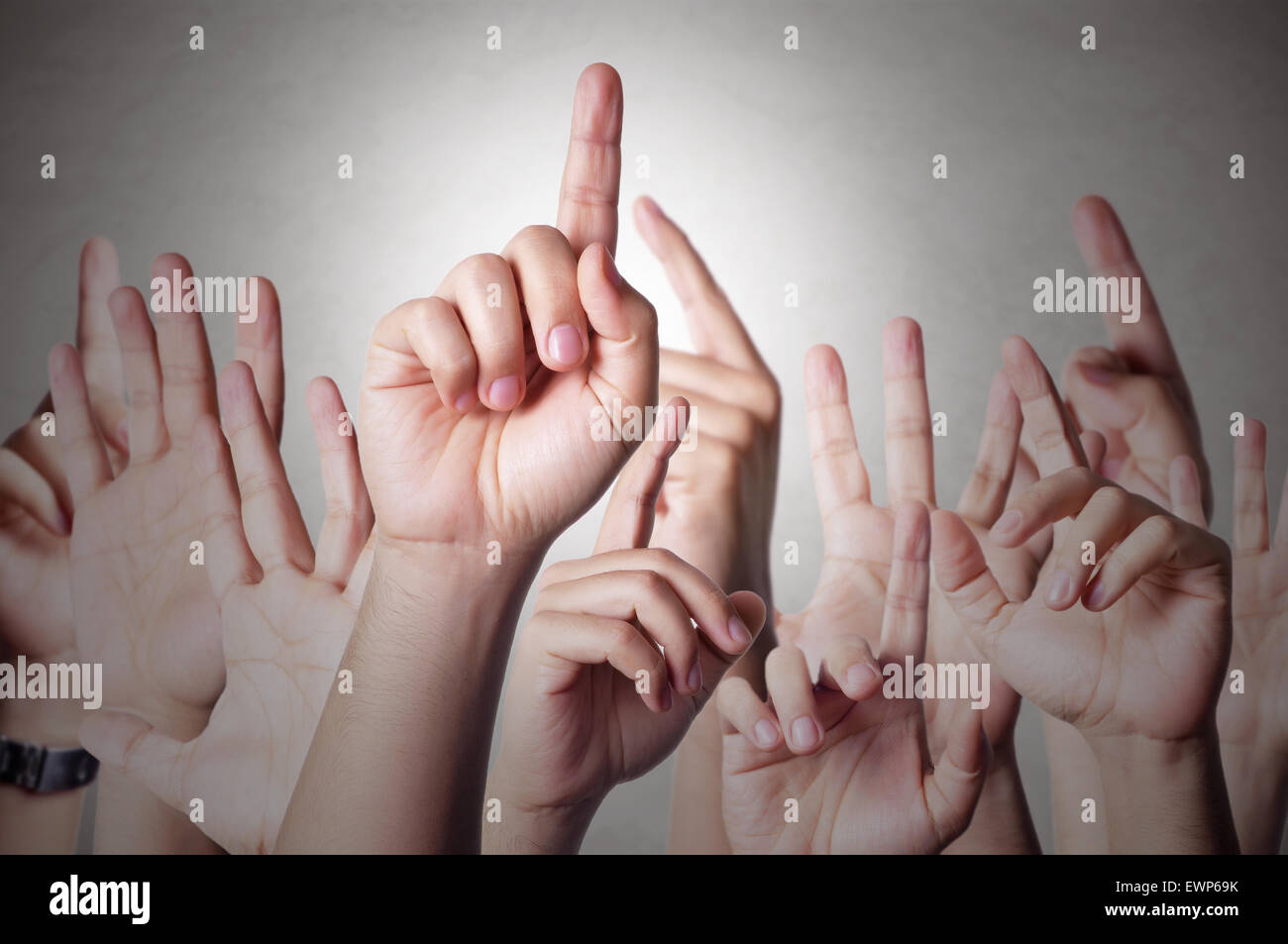Group of people raising hands to answer a question Stock Photo - Alamy