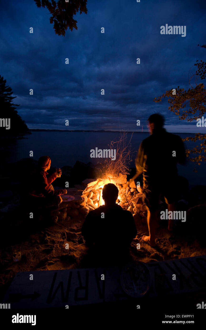 Three people sitting around campfire hi-res stock photography and ...