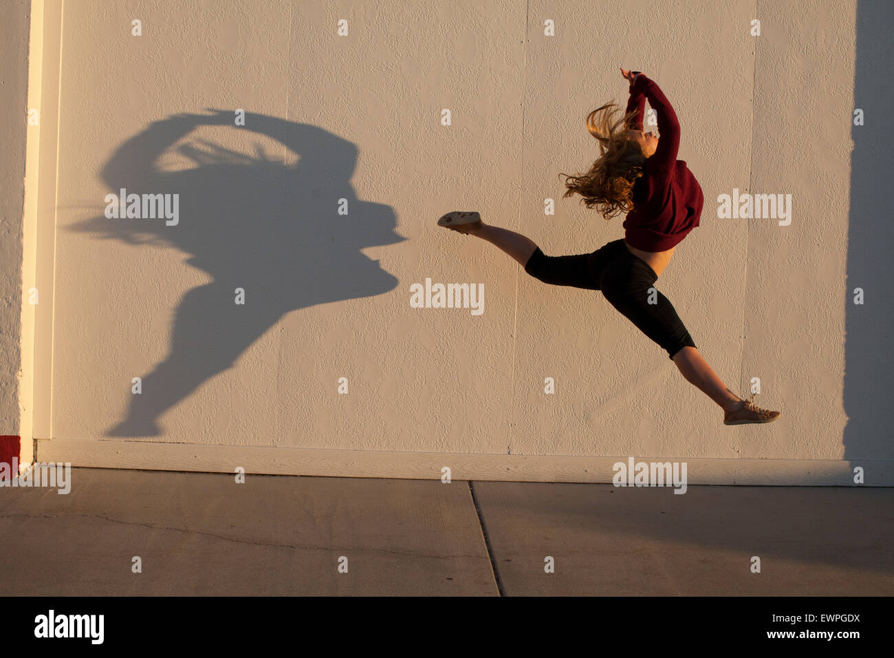 A teenage girl playing with her shadow Stock Photo - Alamy