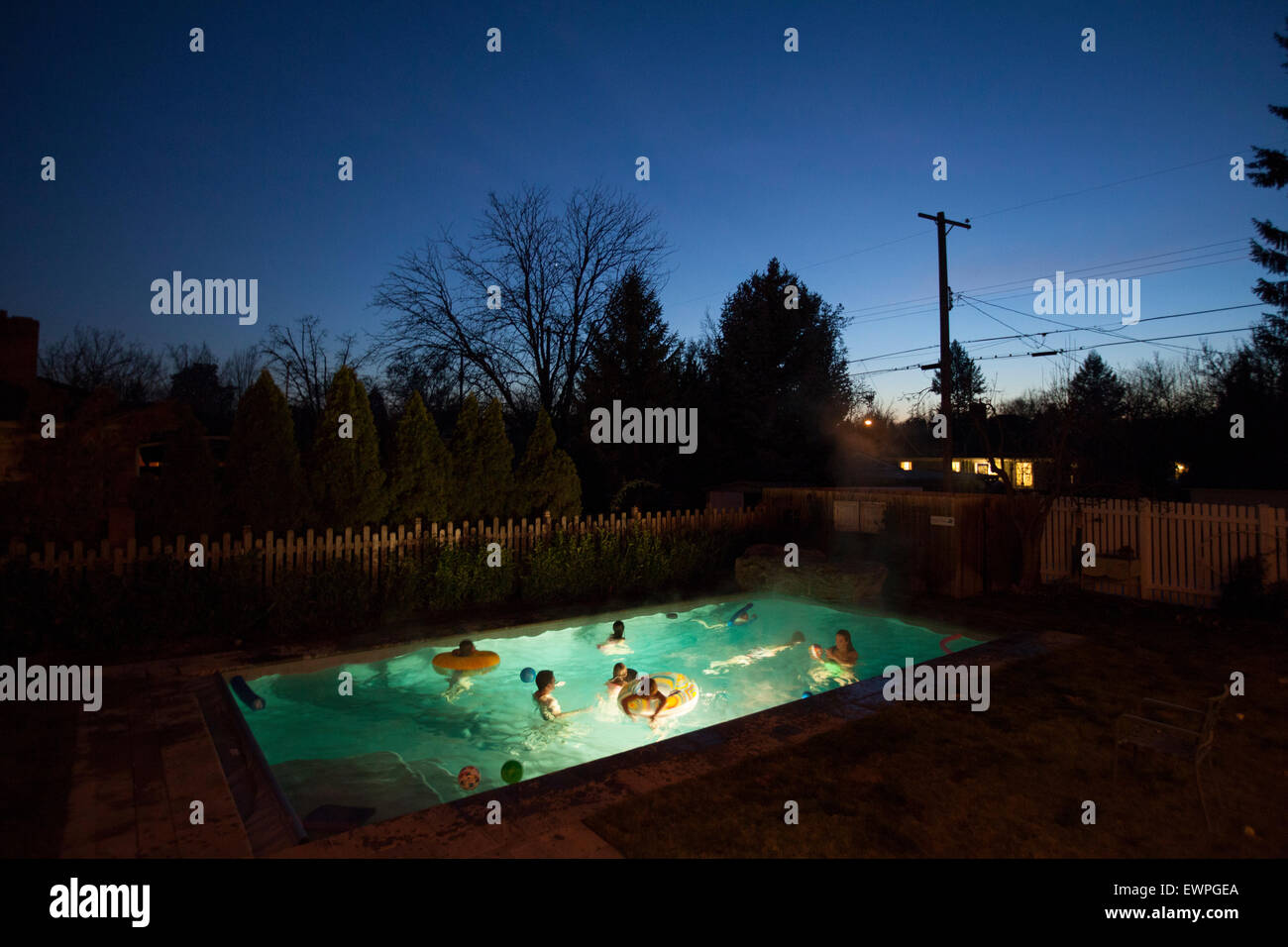 People Swimming In A Pool At Night