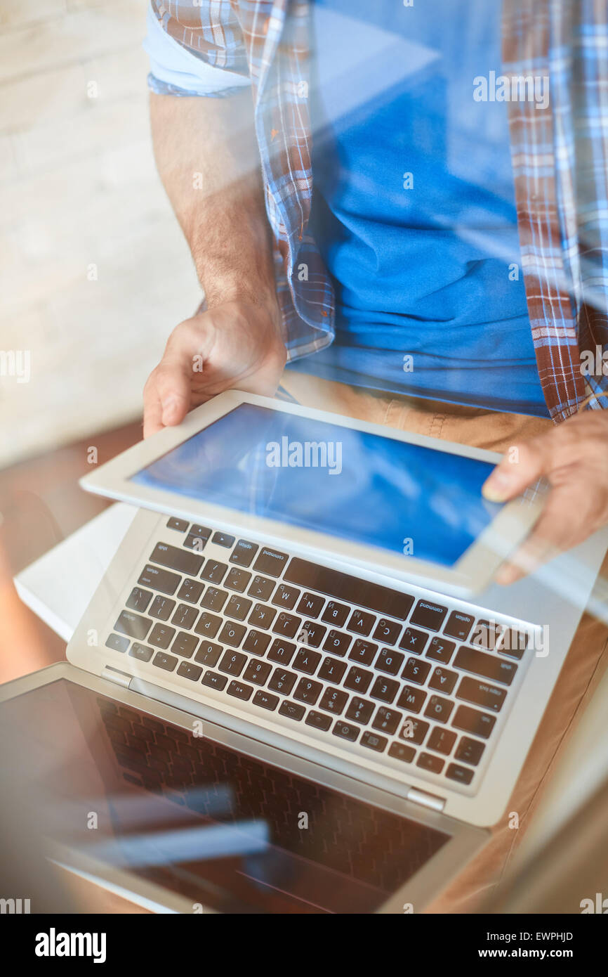 Young man browsing in laptop and touchpad Stock Photo - Alamy