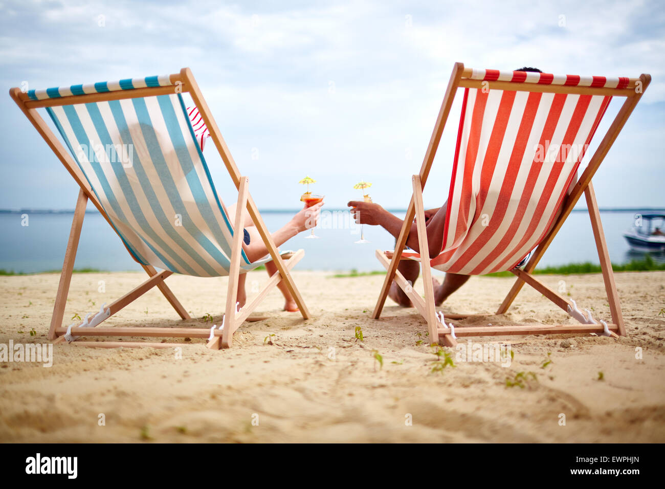 Restful couple toasting with cocktails on the beach Stock Photo - Alamy