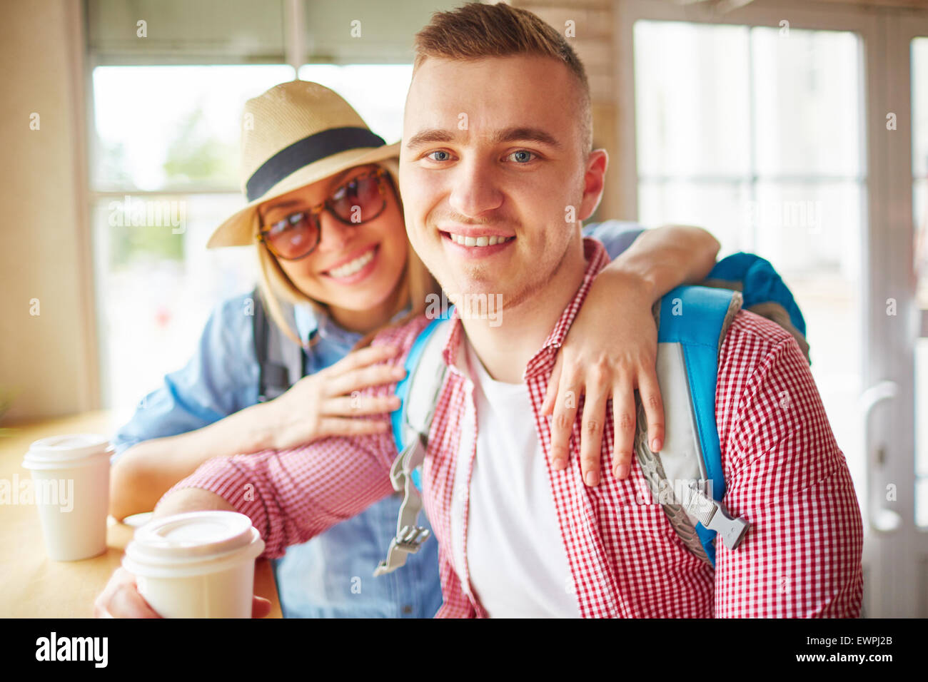 Happy guy with backpack and his girlfriend having drink in cafe Stock ...