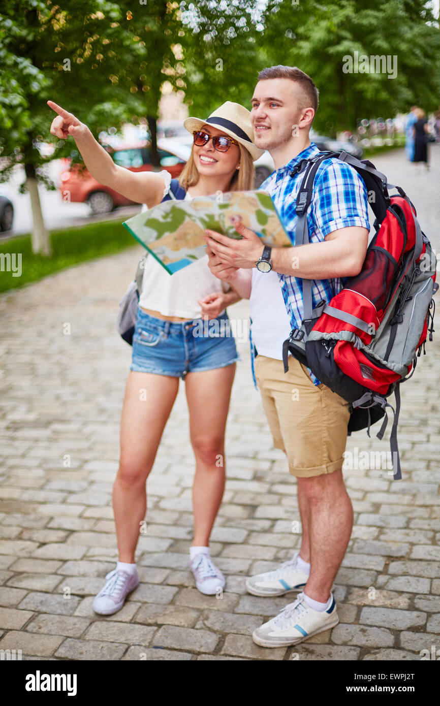 Happy tourists with rucksacks and guide choosing place to visit Stock ...