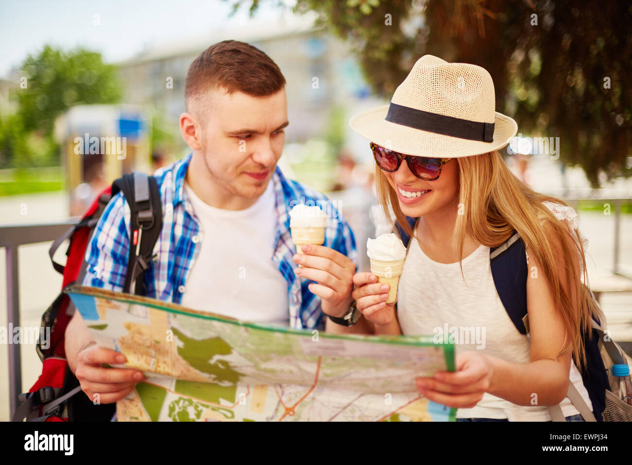 Happy tourists with ice-cream consulting guide in foreign city Stock ...