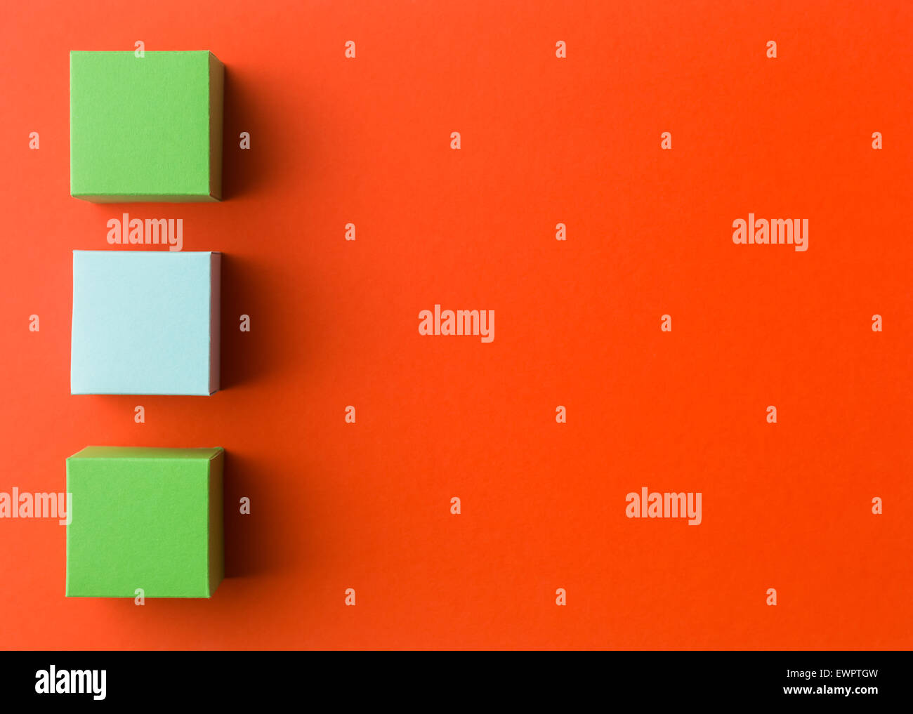 three empty colorful paper cubes in a row on red background. copy space ...